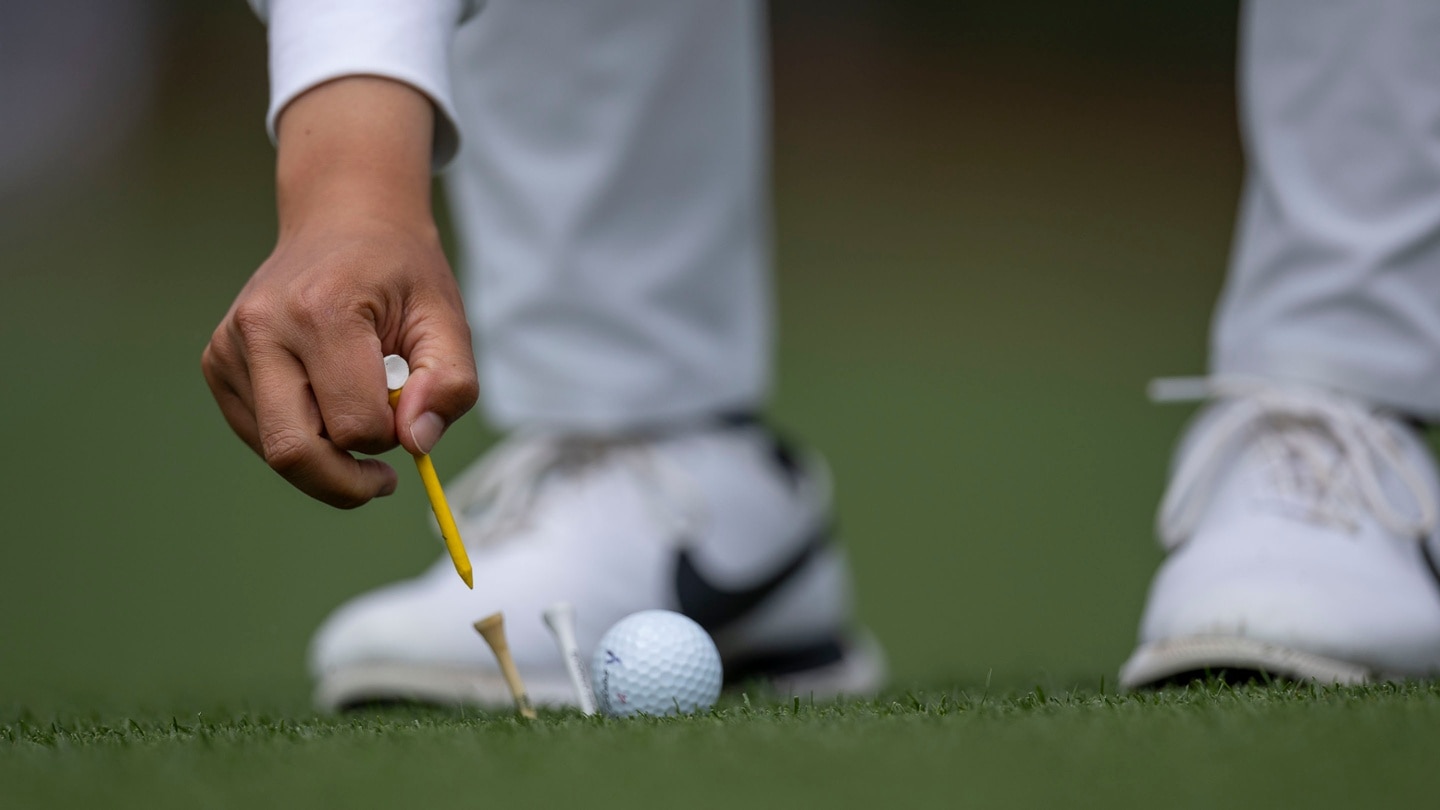 Hsin-Yu Lu of Chinese Taipei marks her ball with a tee on the No. 9 ...